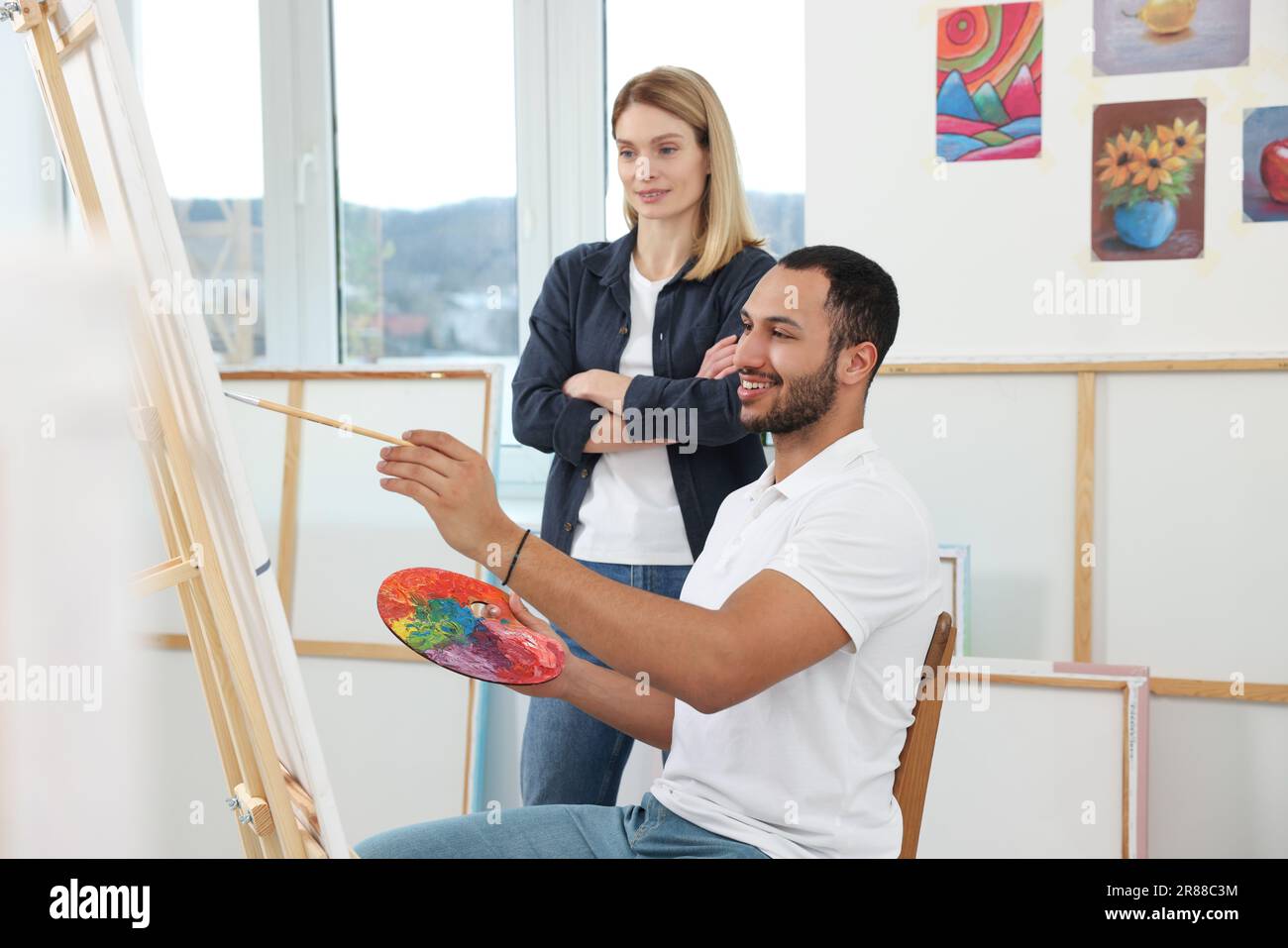 Artist teaching her student to paint in studio. Creative hobby Stock ...