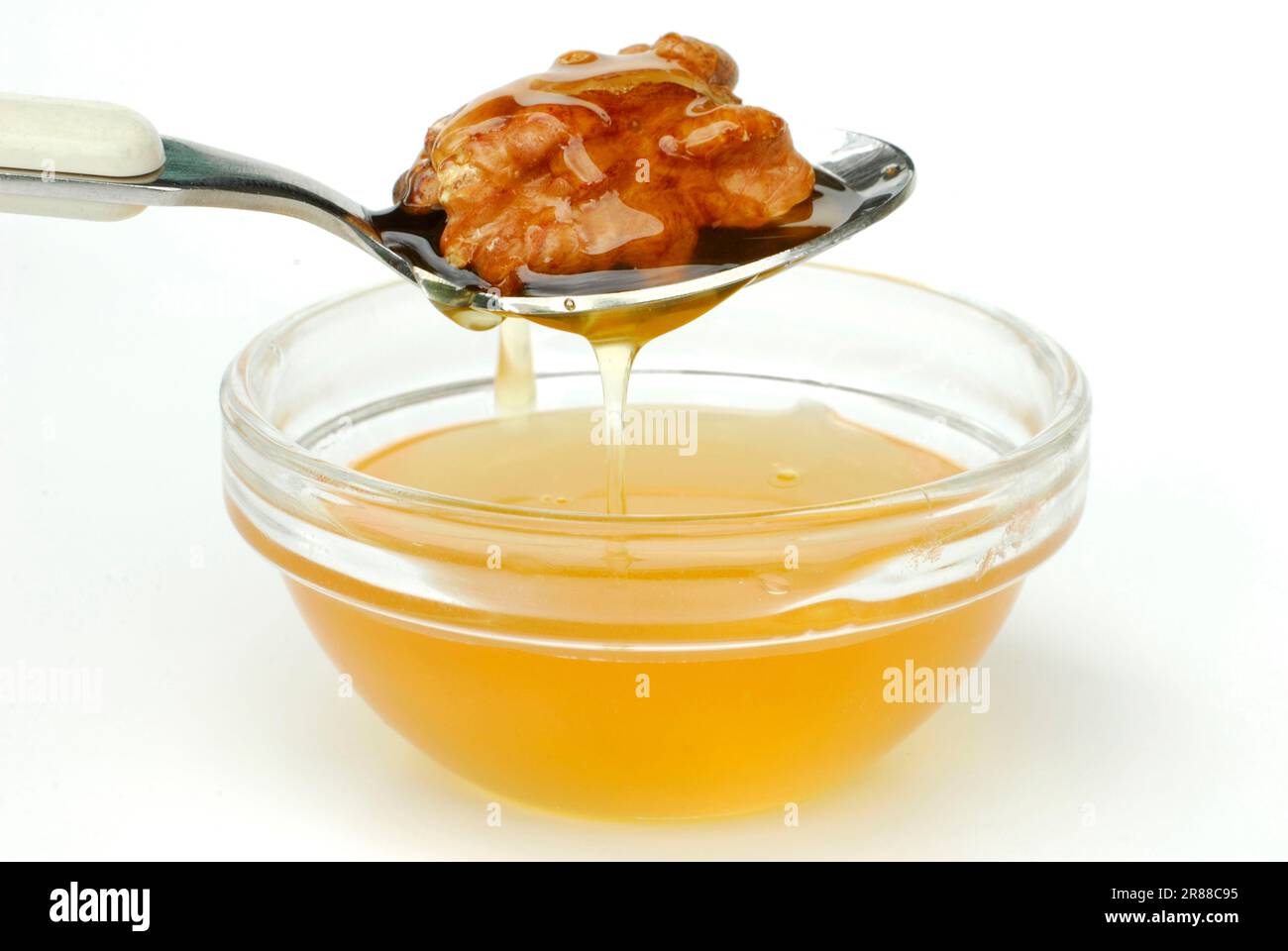 Honey in shell and walnut on spoon Stock Photo - Alamy