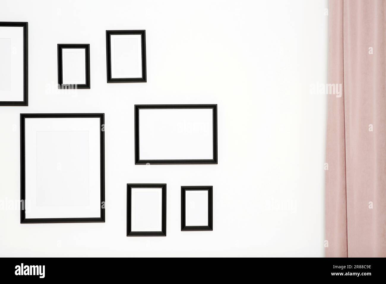 Different empty frames hanging on white wall, space for text Stock ...