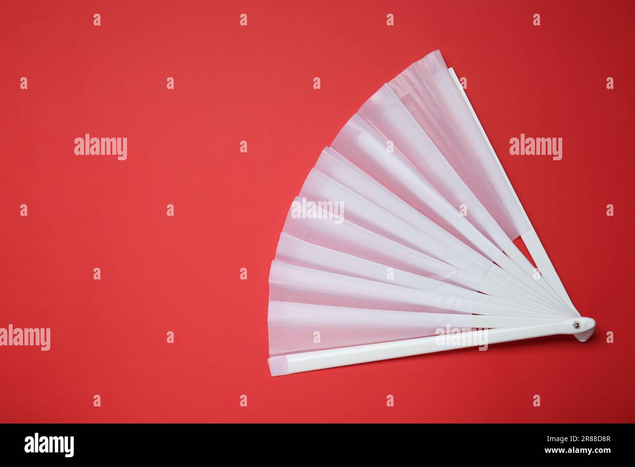 Stylish white hand fan on red background, top view. Space for text ...
