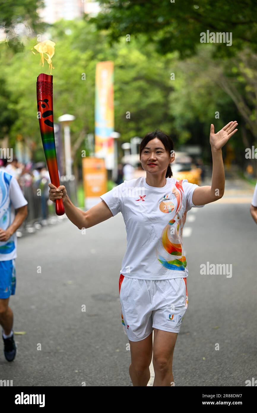 Shenzhen. 20th June, 2023. Torch bearer Zhong Tianshi runs with the ...
