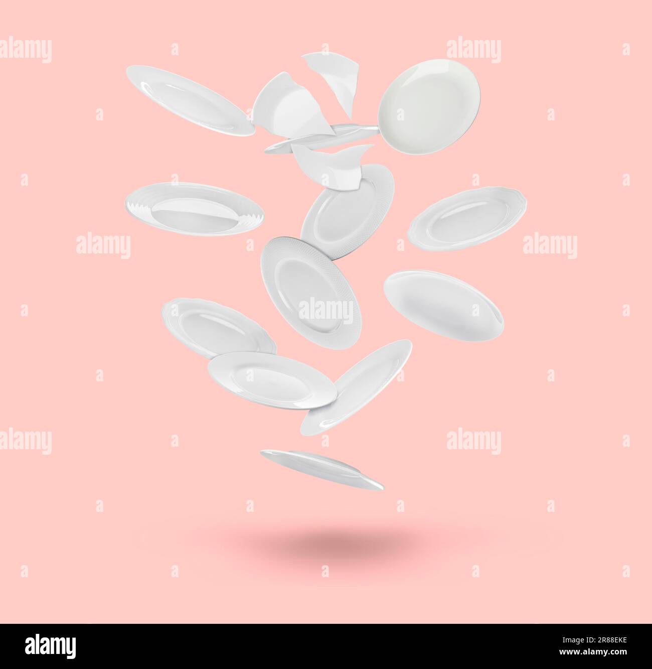 Many white plates falling on pastel pink background Stock Photo - Alamy