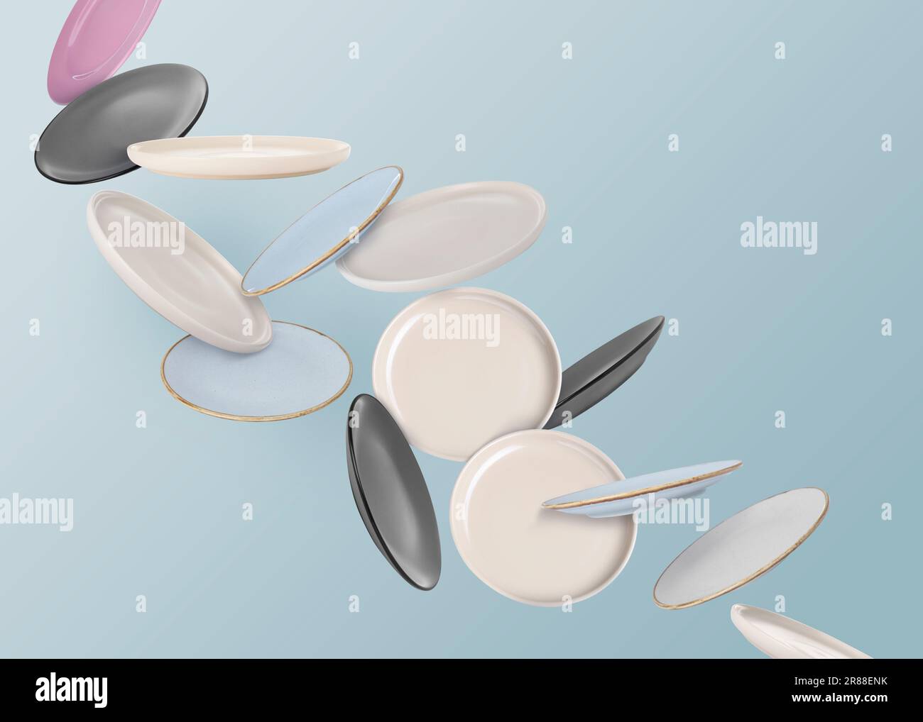 Many different plates falling on pastel light blue gradient background ...
