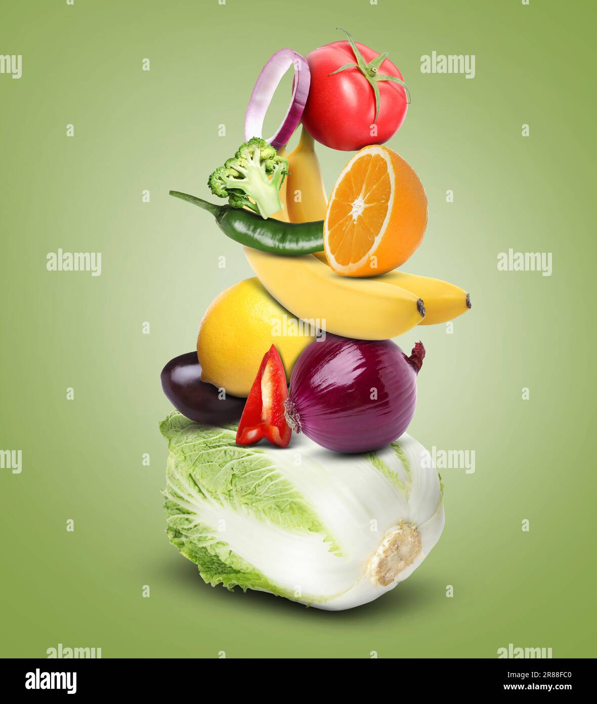 Stack of different vegetables and fruits on pale yellow green ...