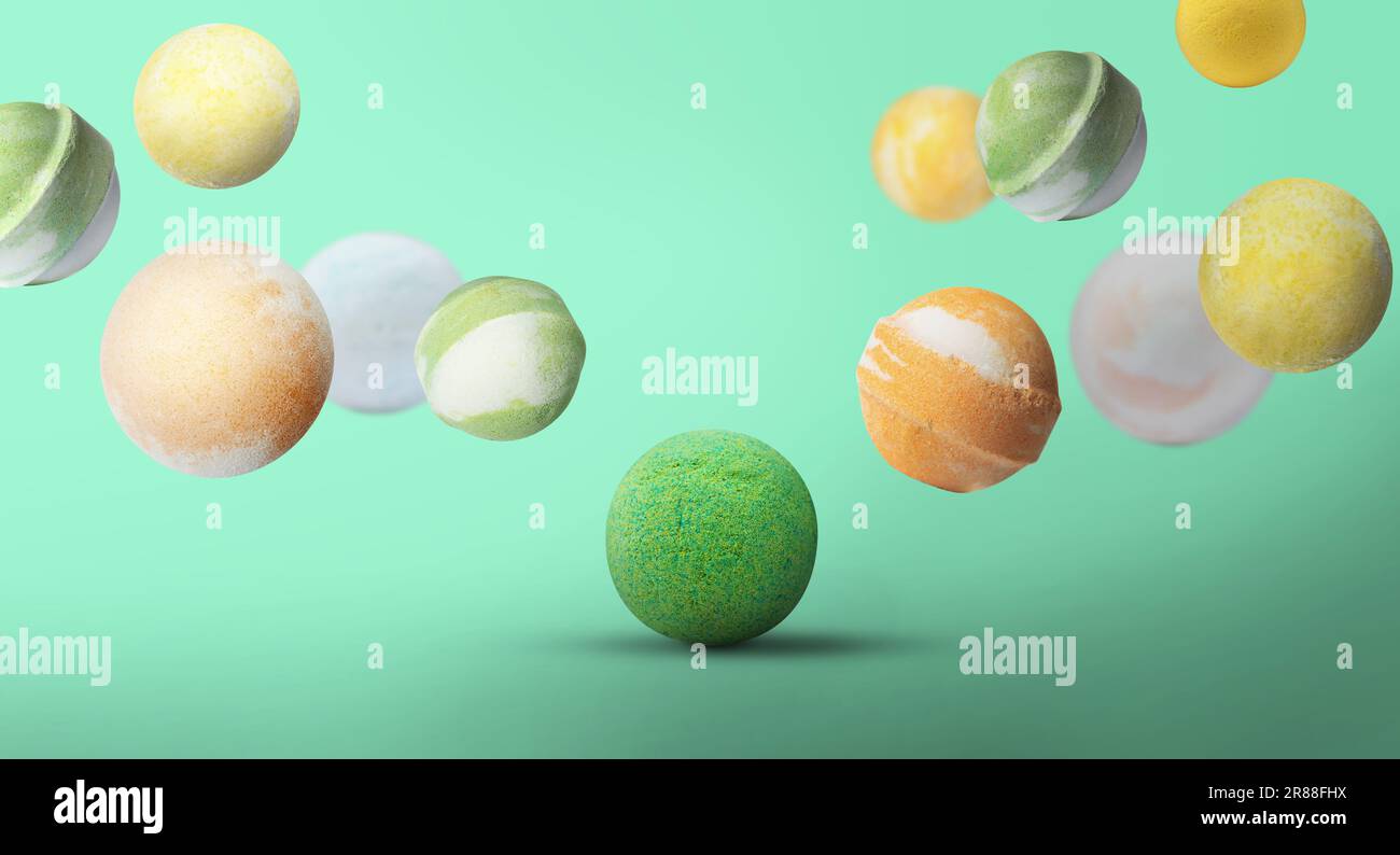 Many different bath bombs falling on pastel turquoise background ...