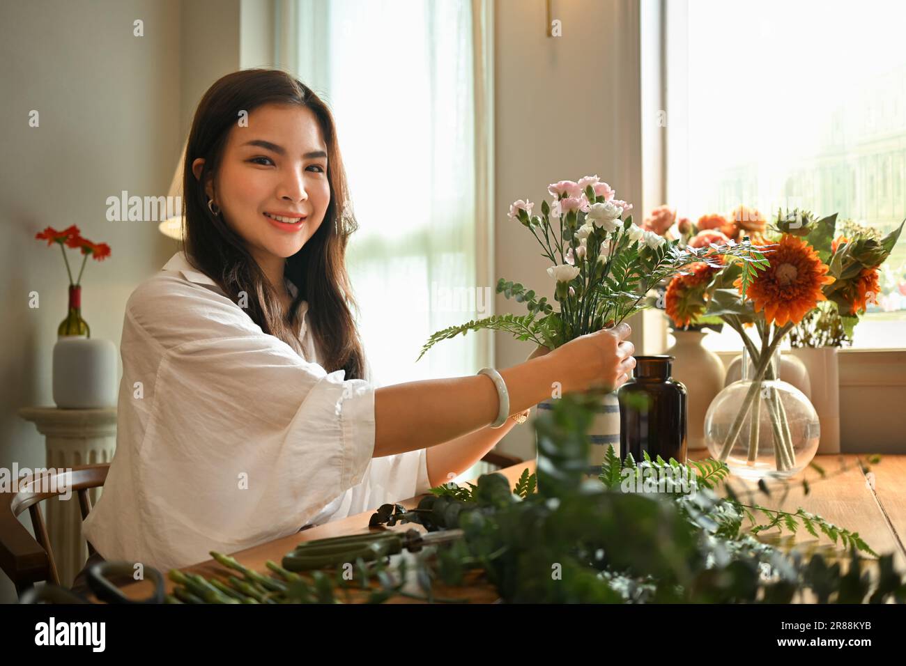 Attractive young female creating beautiful bouquet with different ...