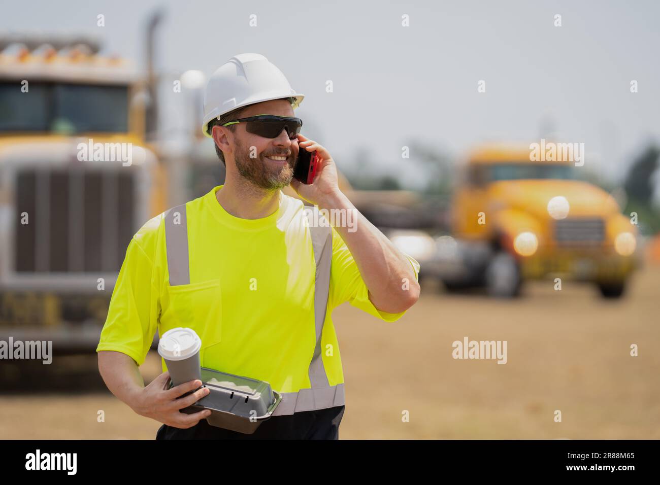 smiling construction site and worker with coffee. caucasian ...