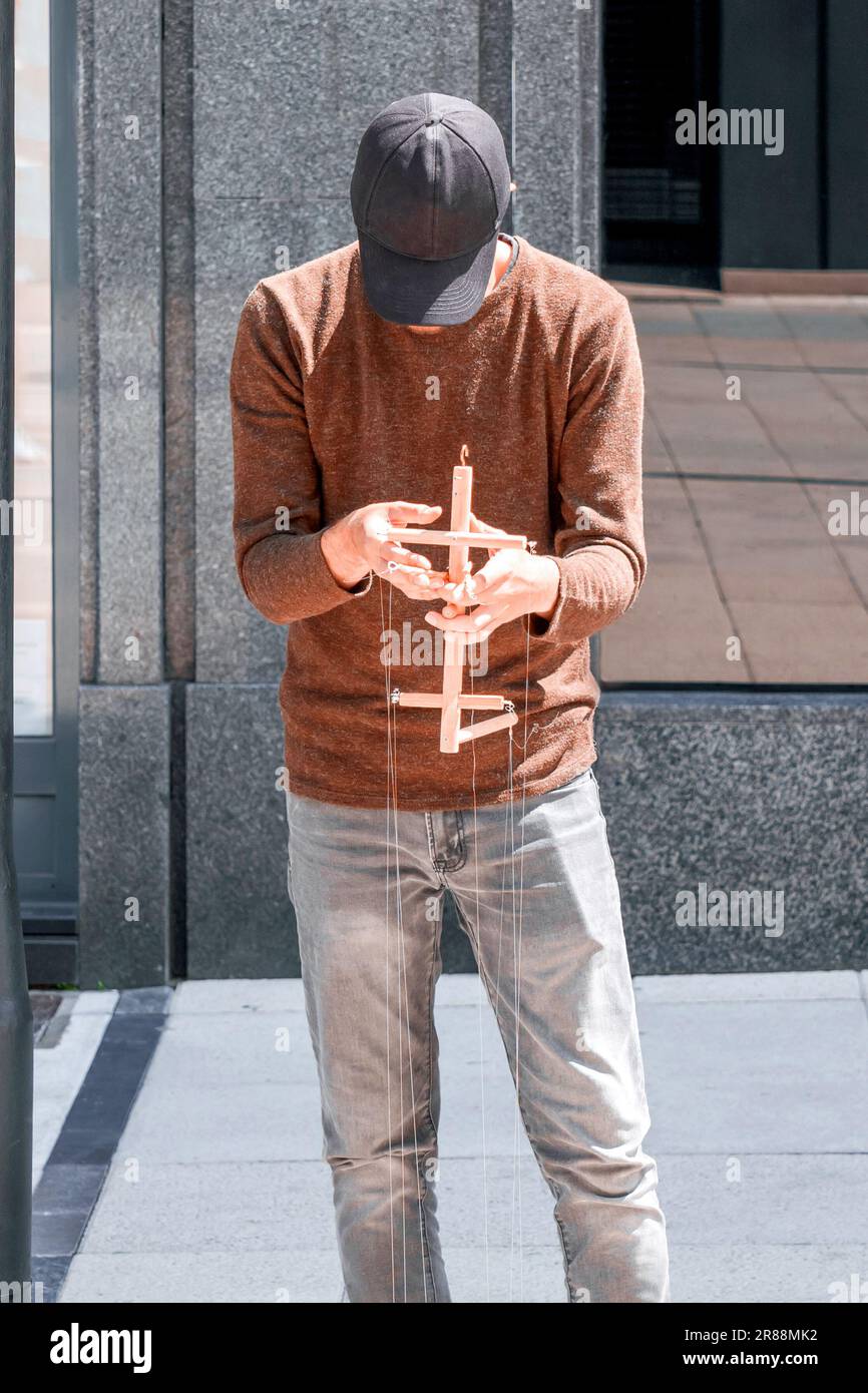 A street performer moving twine with his hands to manipulate an object ...
