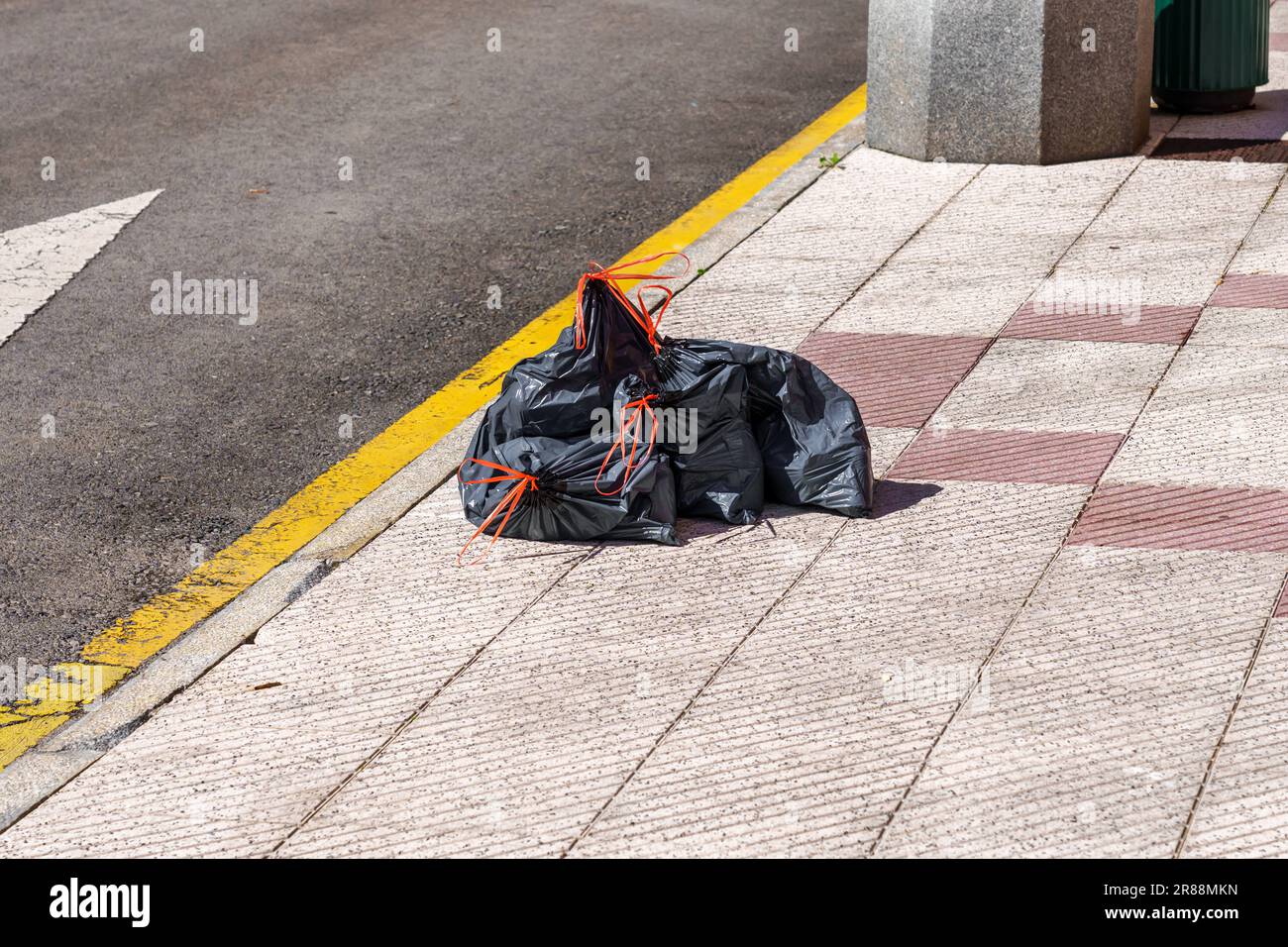 Black plastic bags with garbage on the street Stock Photo - Alamy