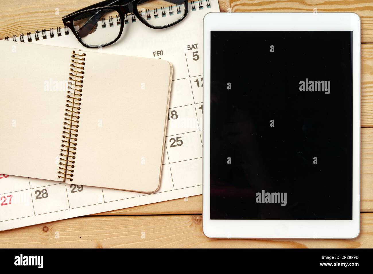 Top view of wooden table with white digital tablet with black screen on ...