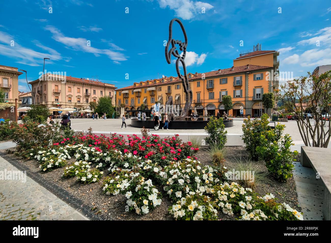 View of flowers and fountain with modern sculpture among colorful ...