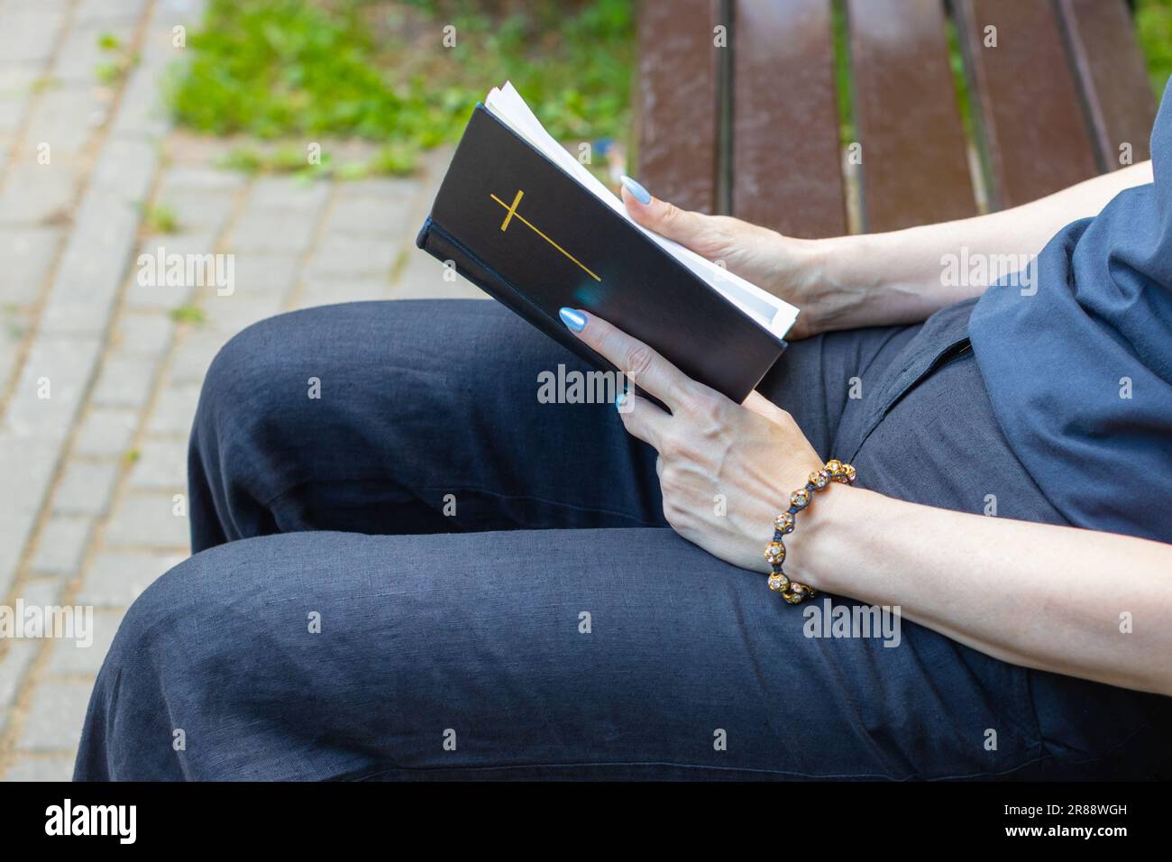 woman reading the bible sitting on a bench. woman reading the bible on ...