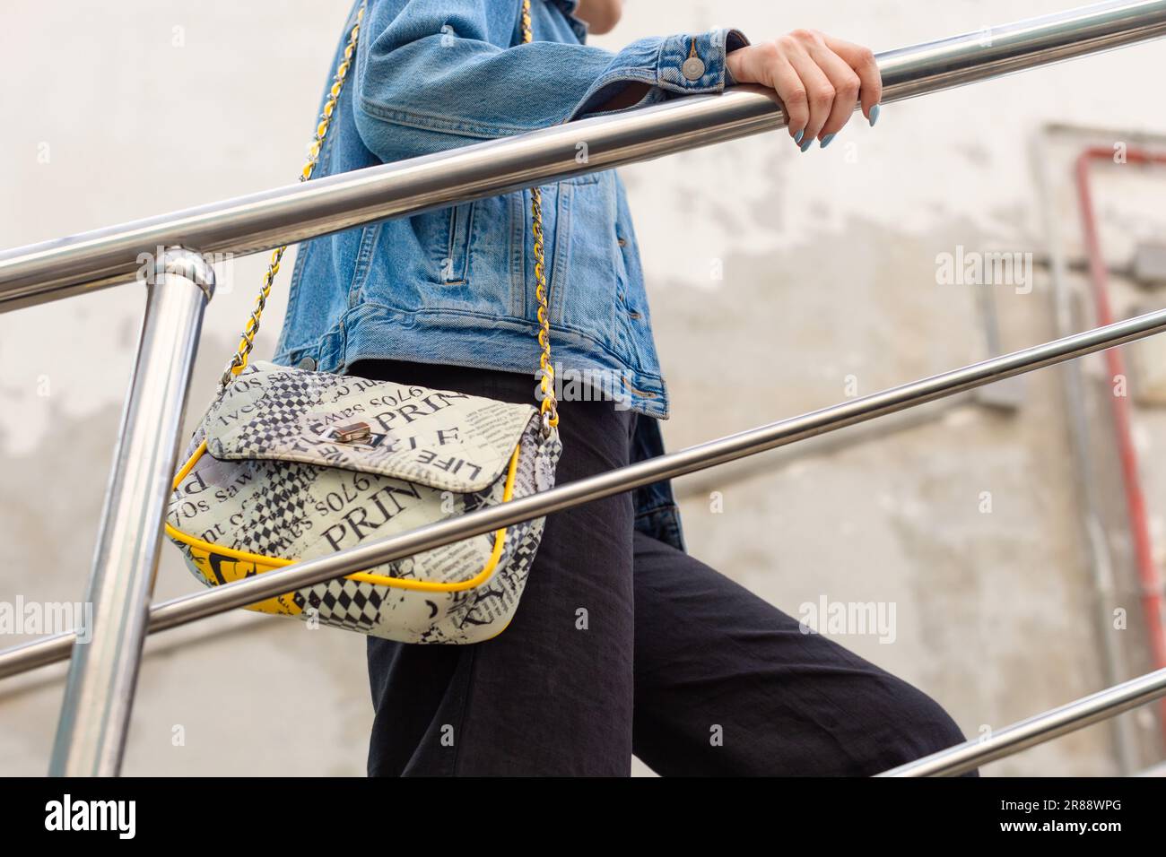 woman climbing the stairs holding on to the railing. a woman walks ...
