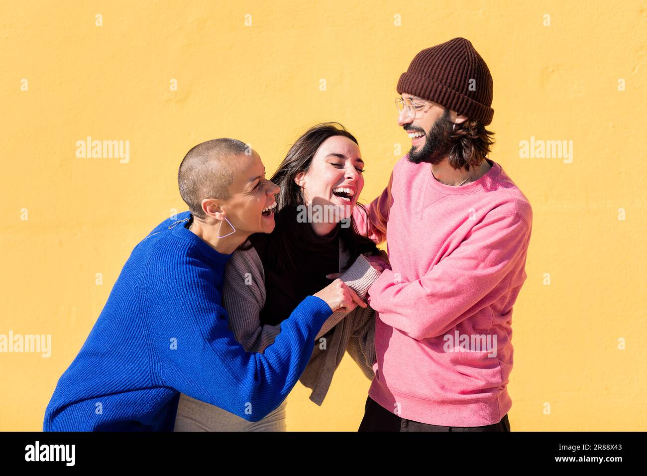 group of three friends laughing and joking around Stock Photo - Alamy