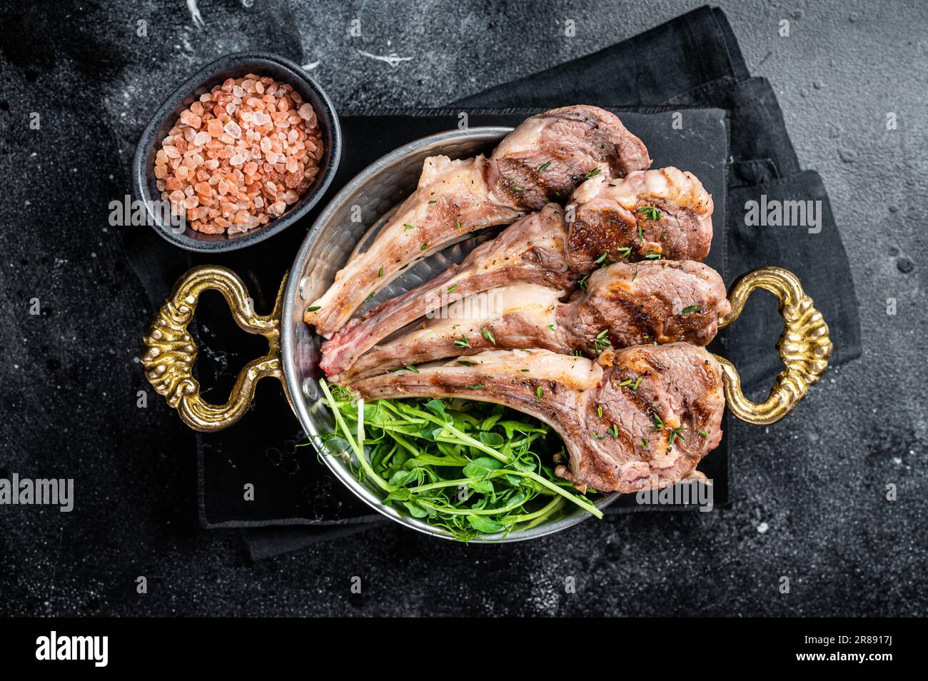 Grilled Lamb mutton Chops steaks in a skillet with green salad. Black ...
