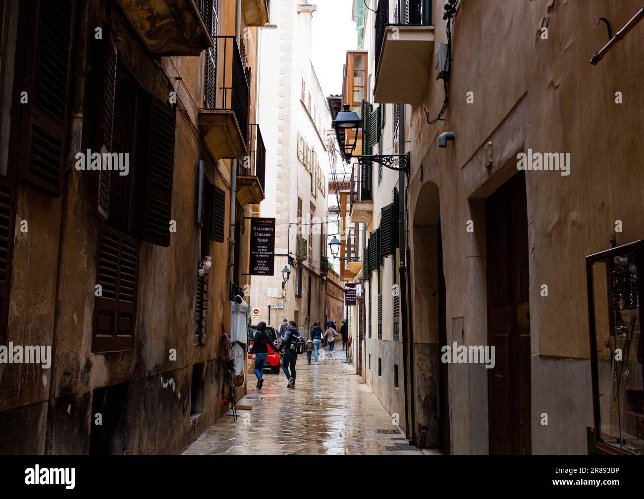 A vintage-style, narrow road is pictured, with people walking along it ...