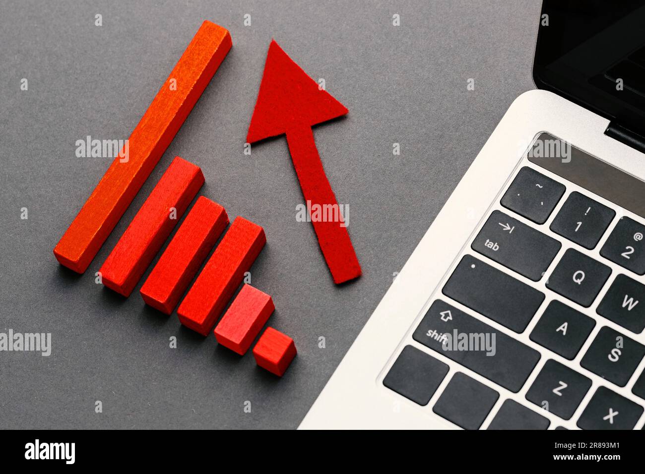 A close-up of a laptop computer keyboard with a red arrow graphic ...