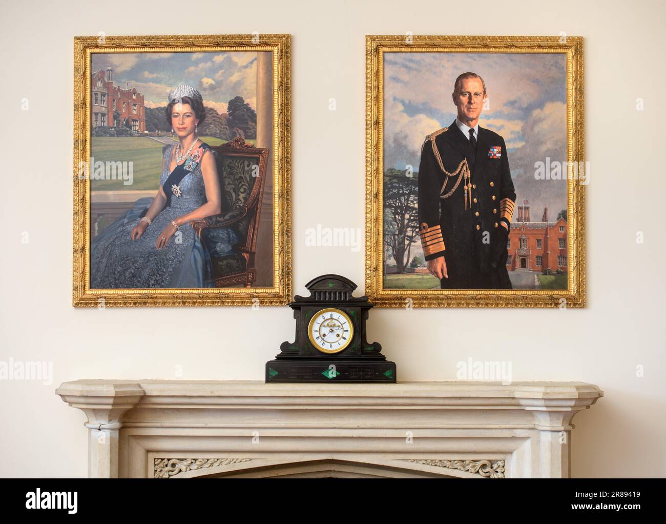 Portraits of HRH Queen Elizabeth II and Prince Phillip hanging above a ...