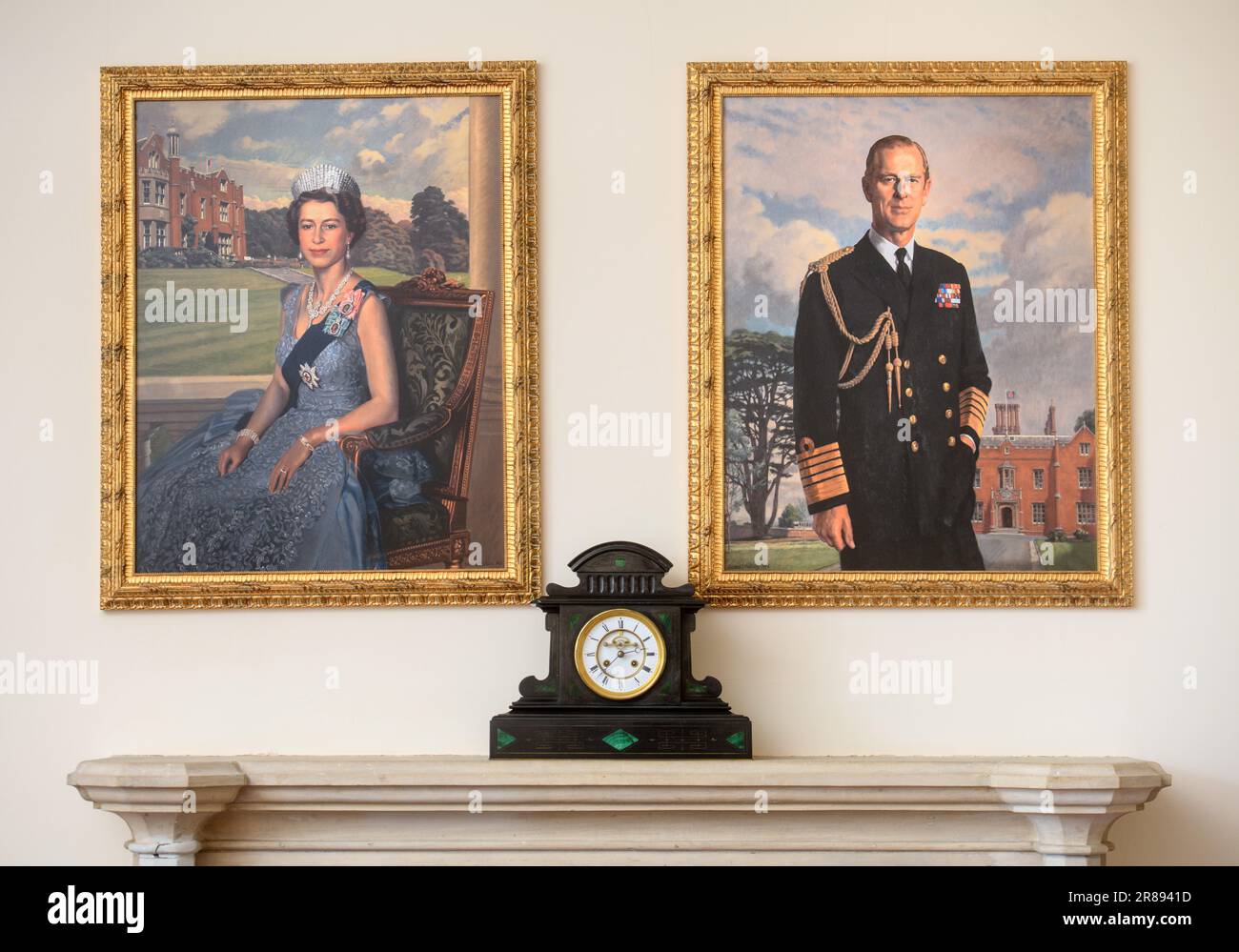 Portraits of HRH Queen Elizabeth II and Prince Phillip hanging above a ...