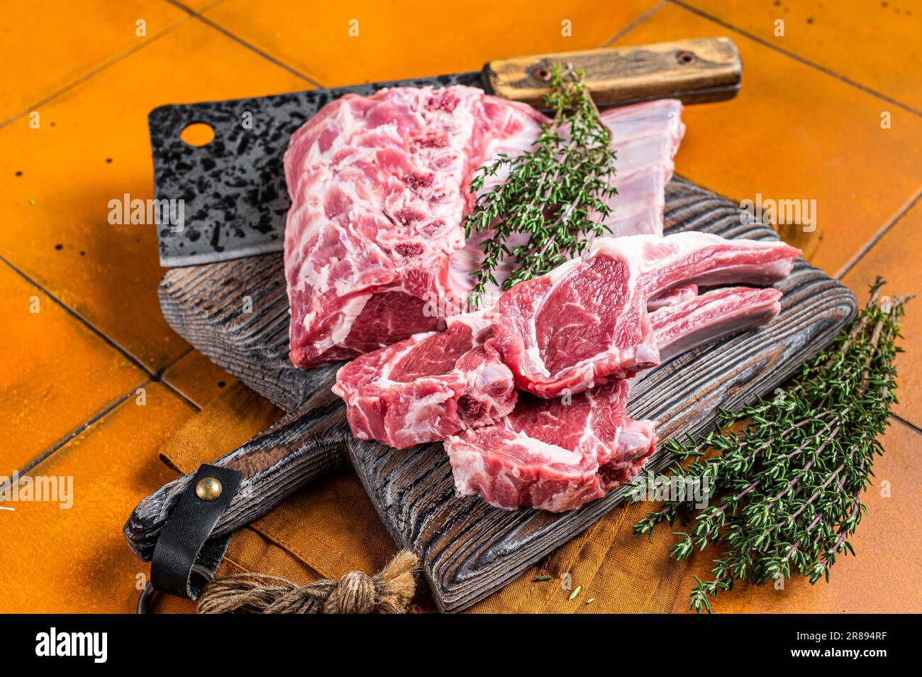 Raw lamb meat chops cutlets on butcher cutting board. Orange background ...