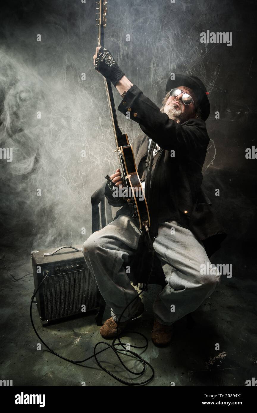 A musician is performing on an electric guitar in a dramatic atmosphere ...