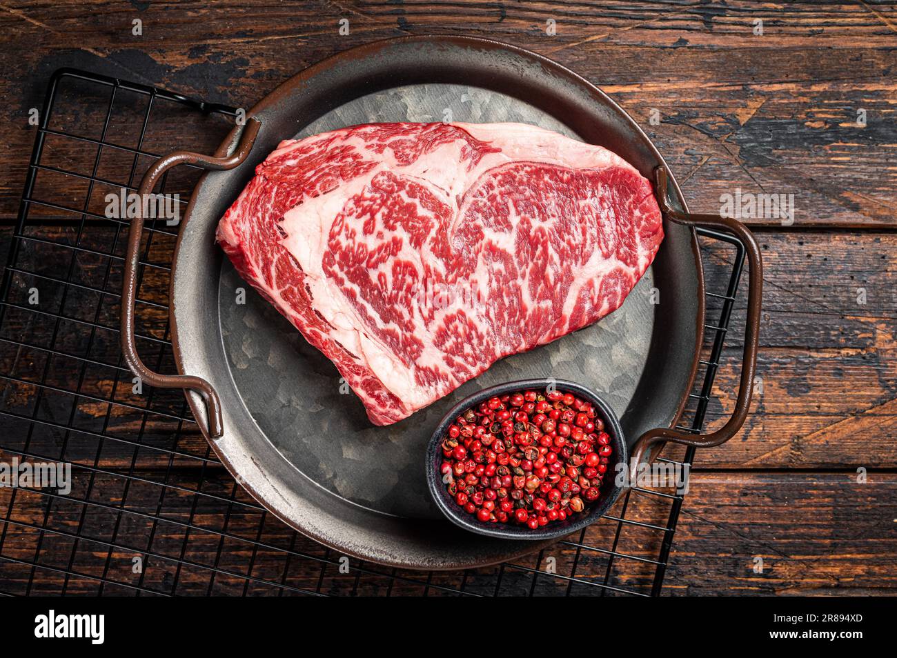 Raw wagyu rib eye beef meat steak in steel tray. Wooden background. Top ...
