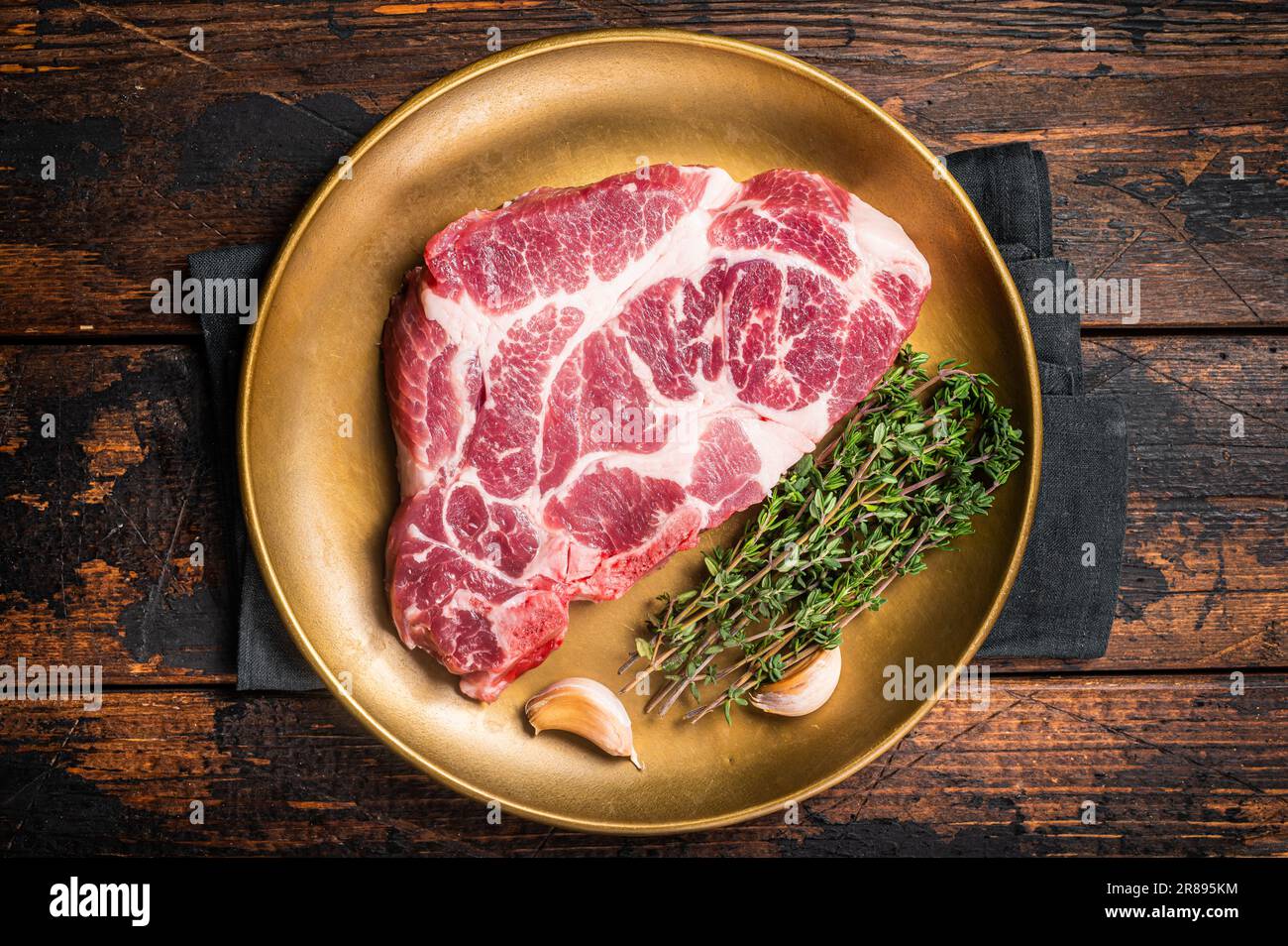 Marble pork steak, raw neck meat with thyme. Wooden background. Top ...