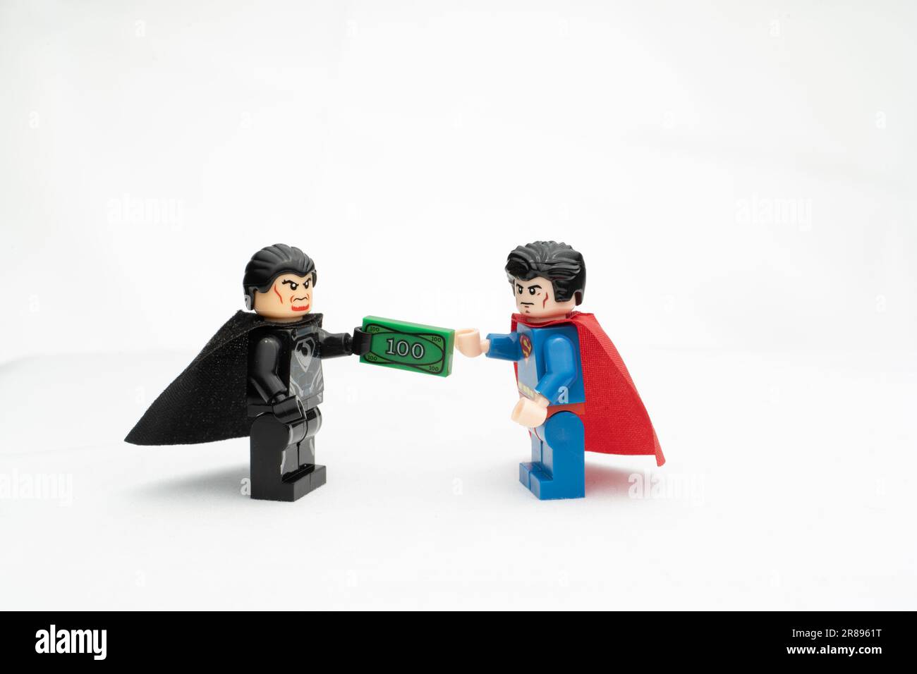 Two smiling Lego superhero figures exchanging hundred dollar bills in a ...