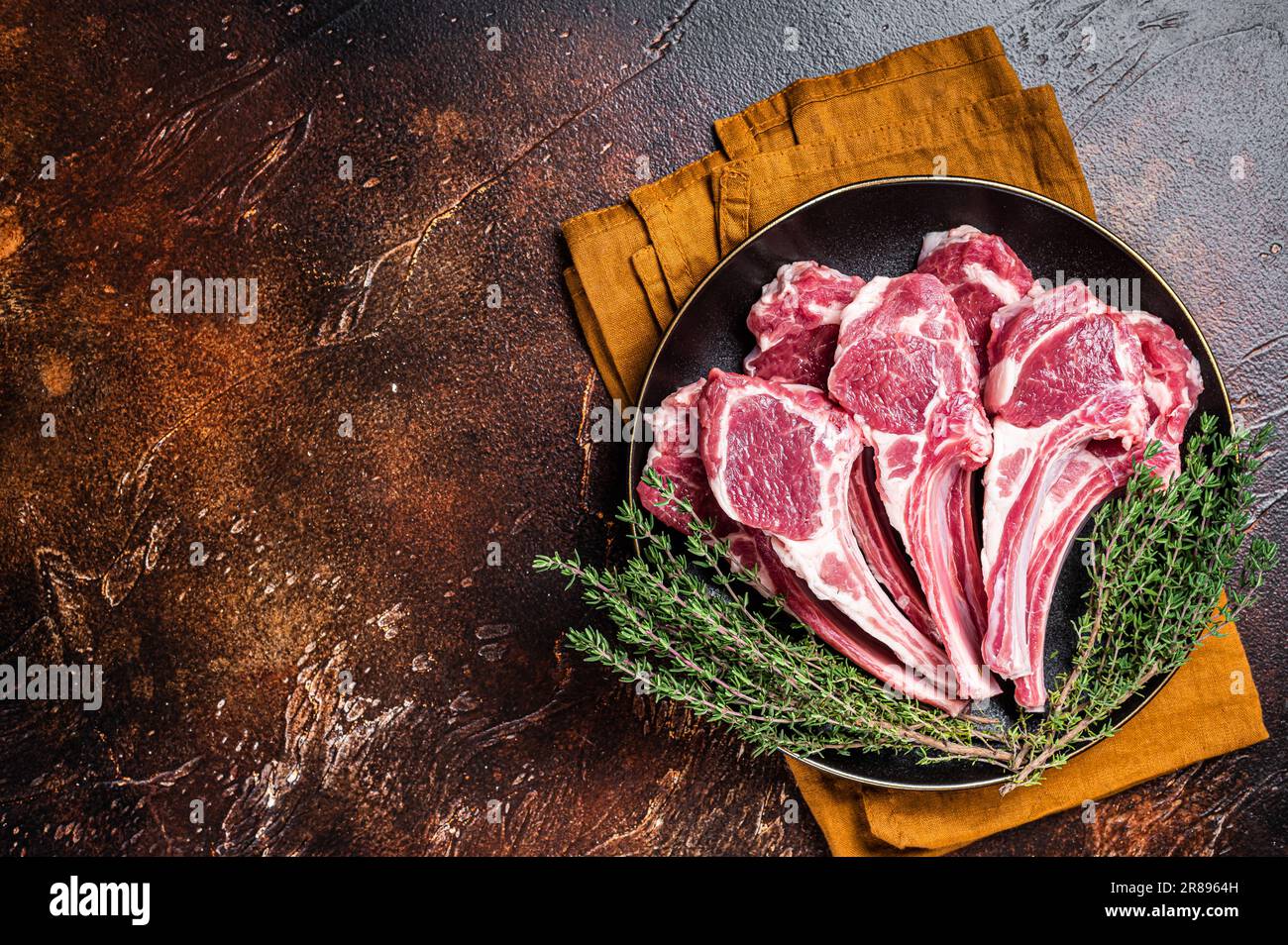 Raw lamb chops, fresh mutton meat cutlets on a ribs. Dark background. Top view. Copy space Stock ...