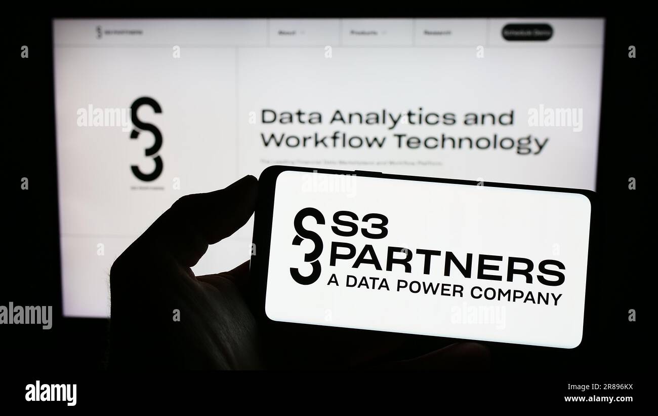 Person holding mobile phone with logo of American data analytics ...