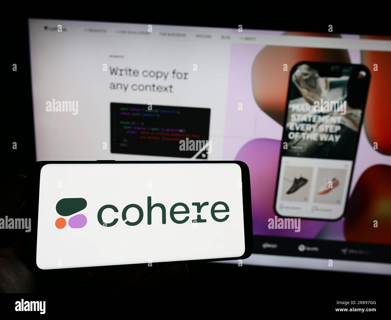 Person holding cellphone with logo of Canadian AI company Cohere Inc ...