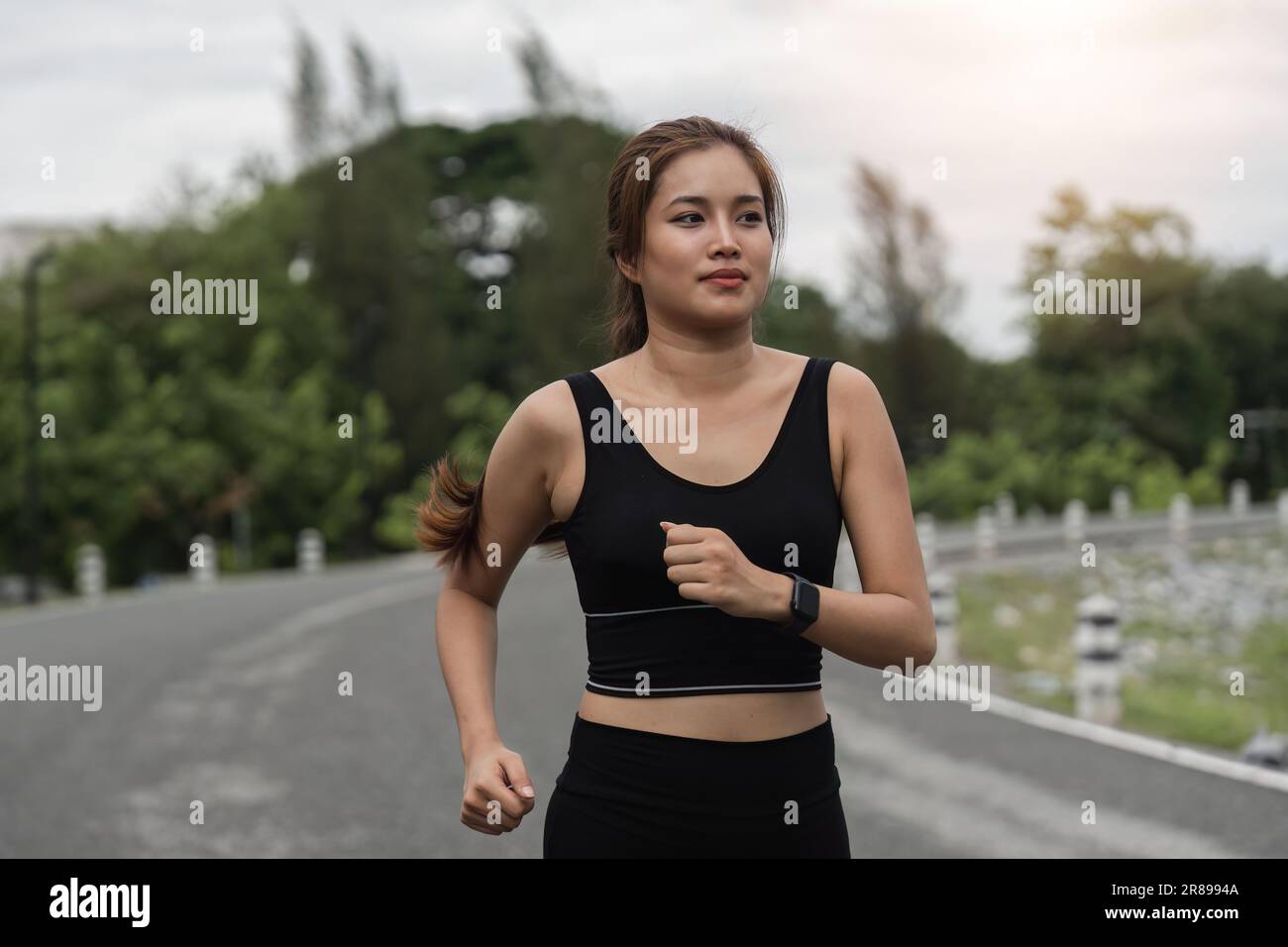 Happy woman wearing sportswear jogging in the park. Young beautiful ...