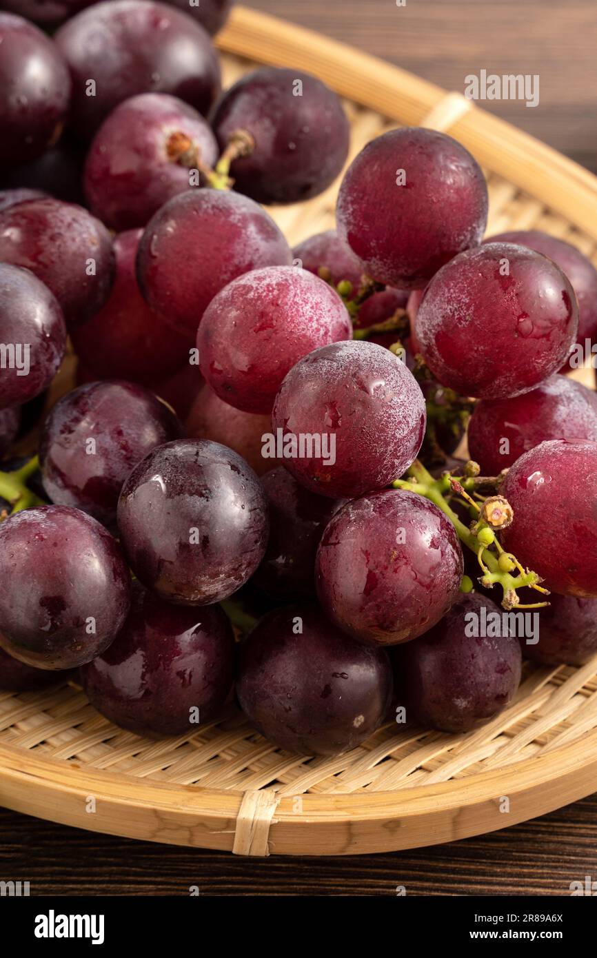 Delicious bunch of purple grapes fruit on a tray over wooden table ...
