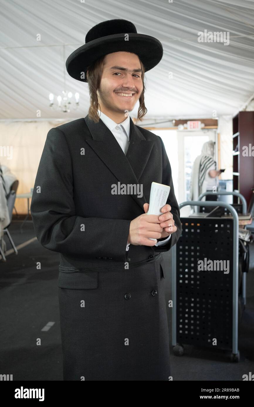 A Hasidic young man collects charity in a tent synagogue in Monsey ...