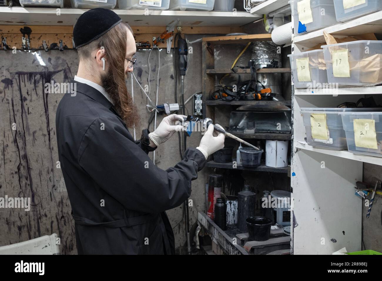 An orthodox Jewish craftsman who refurbishes tefillin, paints one of ...
