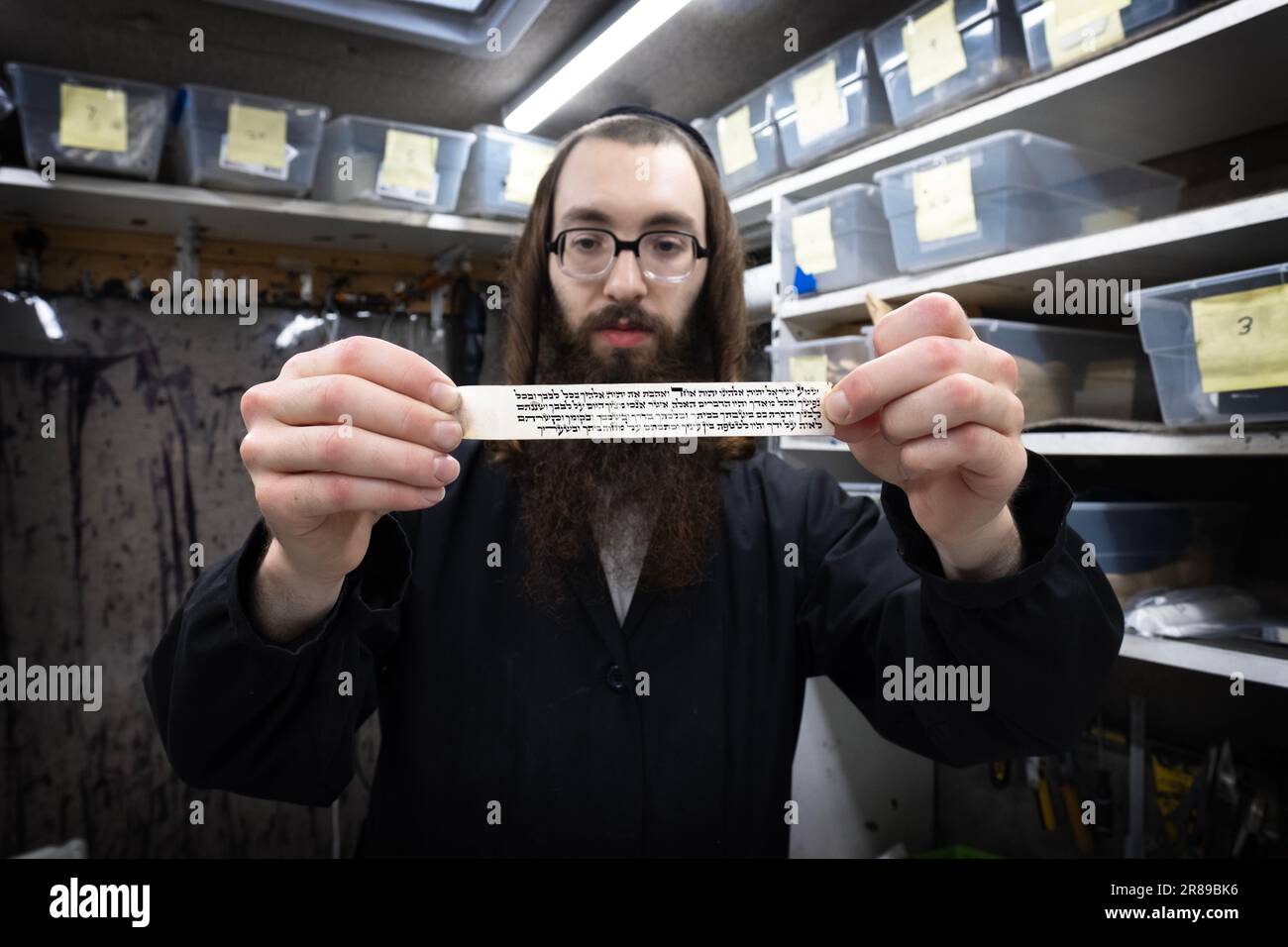 An orthodox Jewish young man hold a small piece of parchment used ...