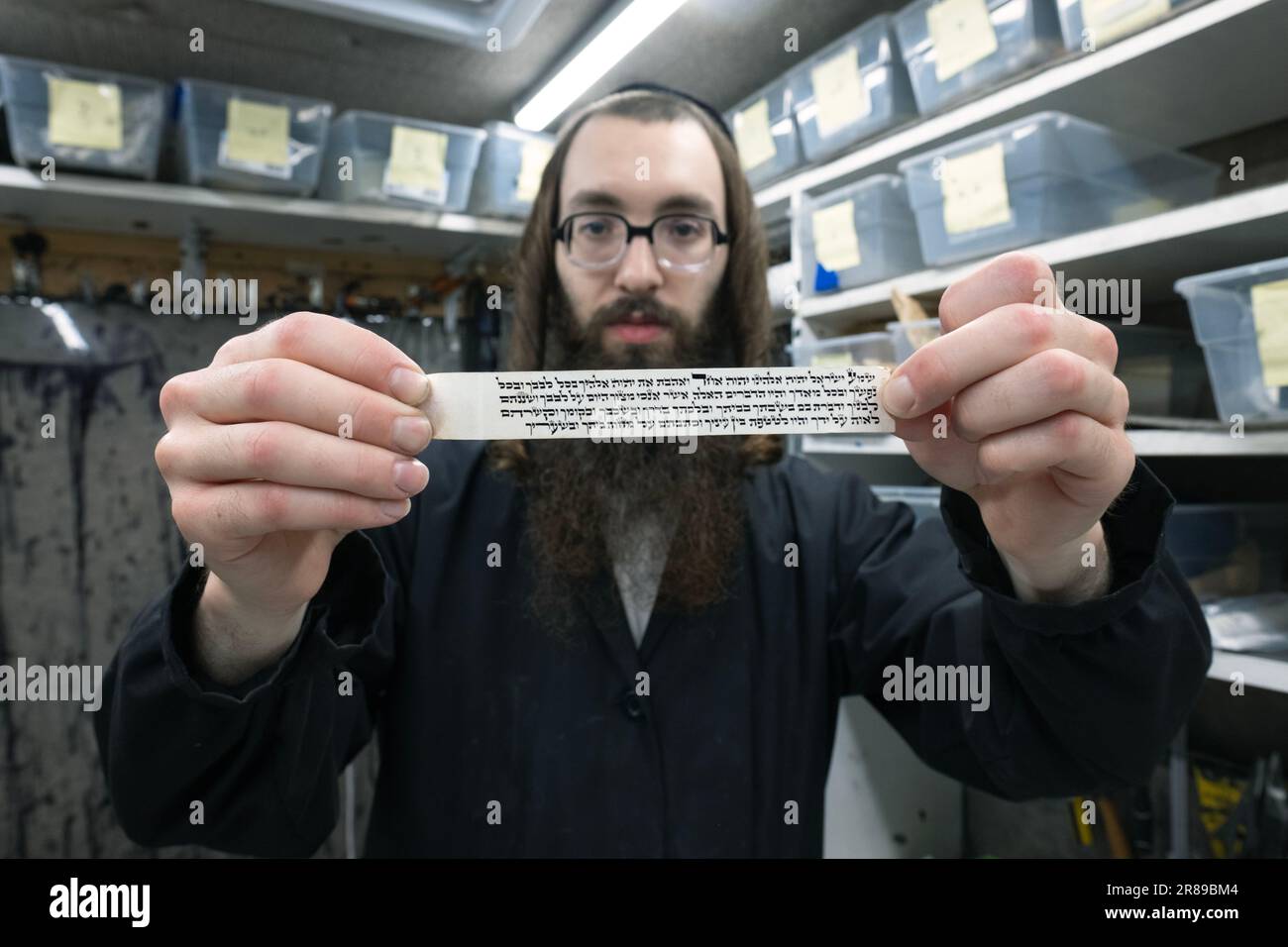 An orthodox Jewish young man hold a small piece of parchment used ...