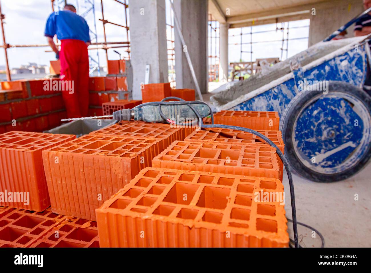 ACU power tool, drilling machine placed on heap of red blocks, in ...