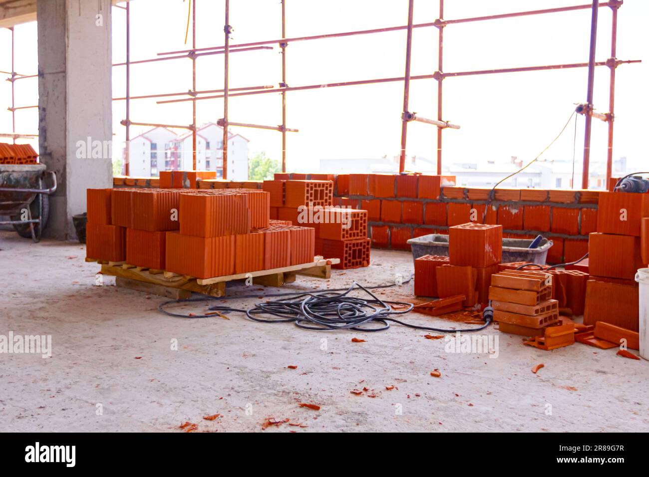 Wooden pallet with pile of red blocks, in the background is wall ...