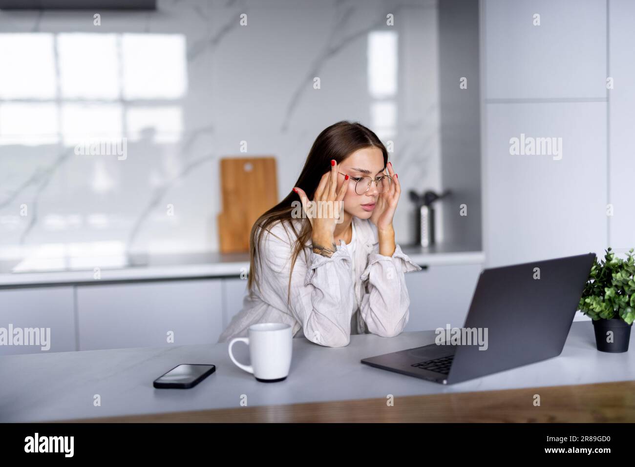 Shot of stressed business woman working from home on laptop looking ...