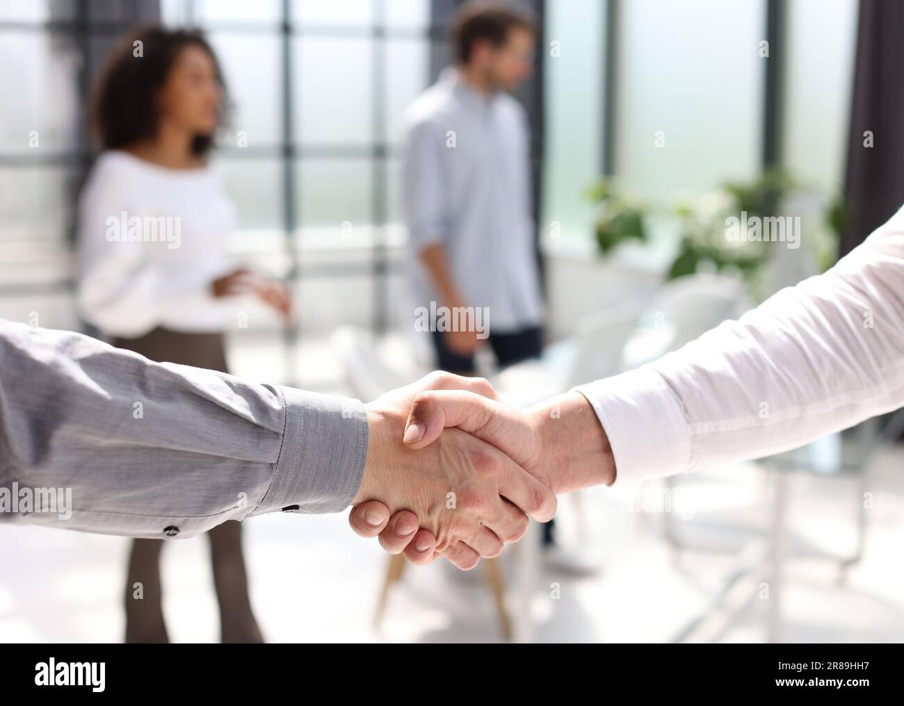 Close up people shaking hands on blurred background Stock Photo - Alamy