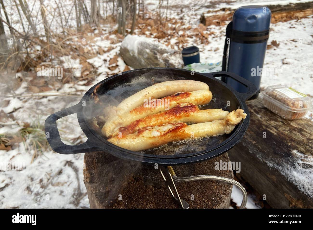 Sausages in bowler in the forest in winter. Camping food making. Foods ...