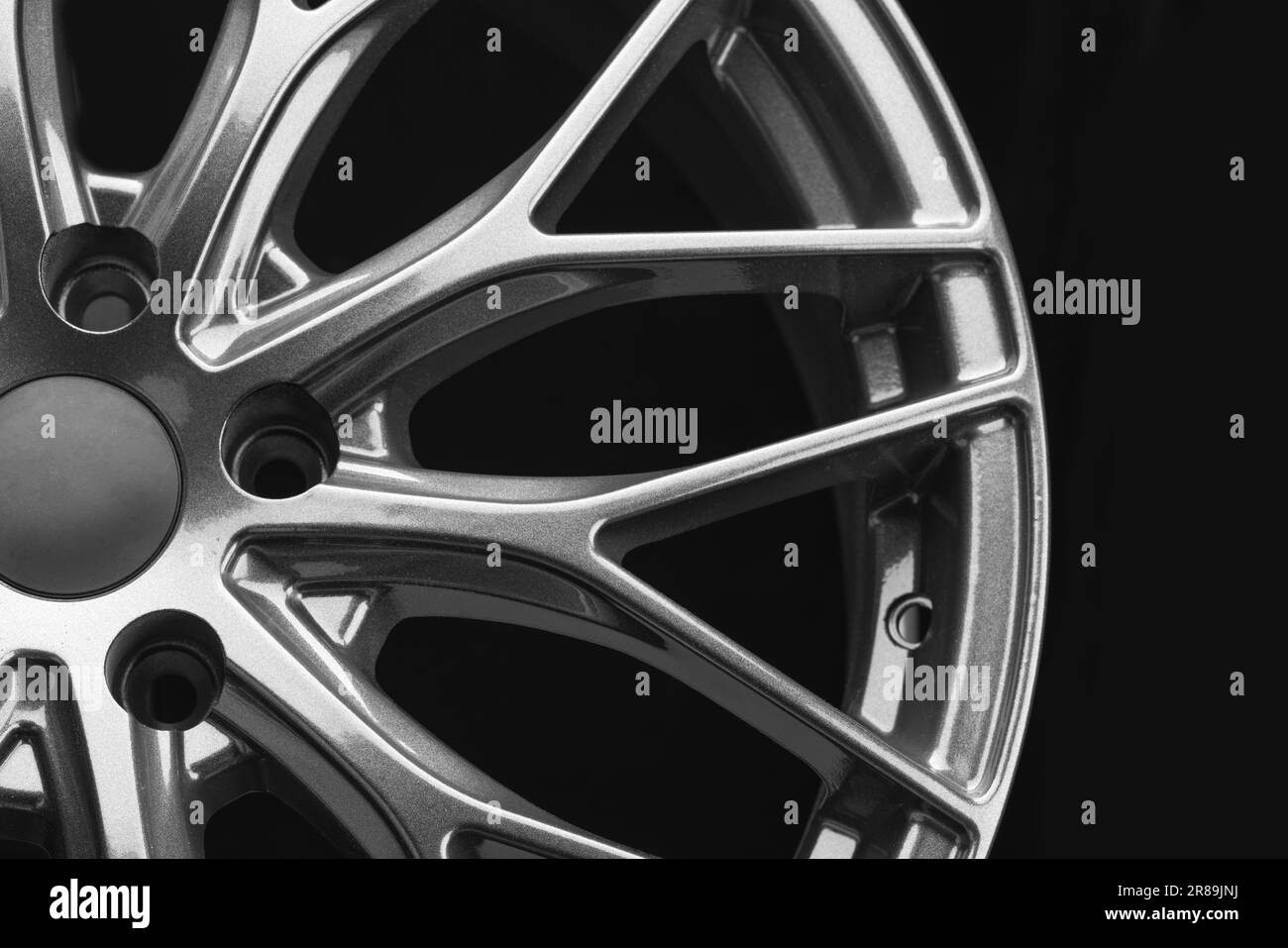 Beautiful gray aluminum disc cast wheel close-up on a black background ...