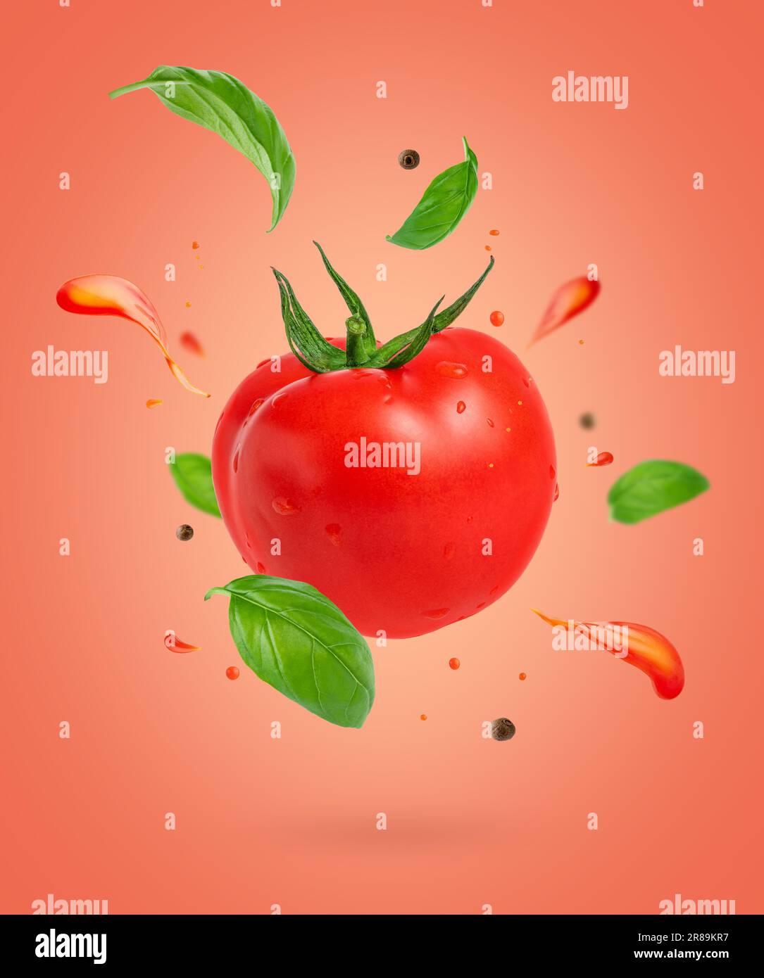 Flying tomato with splashes and basil leaves on red background Stock ...