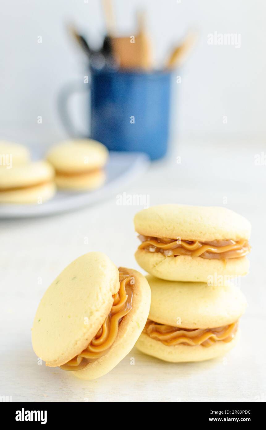 Alfajores cookies filled with dulce de leche. Stacked. Kitchen utensils ...