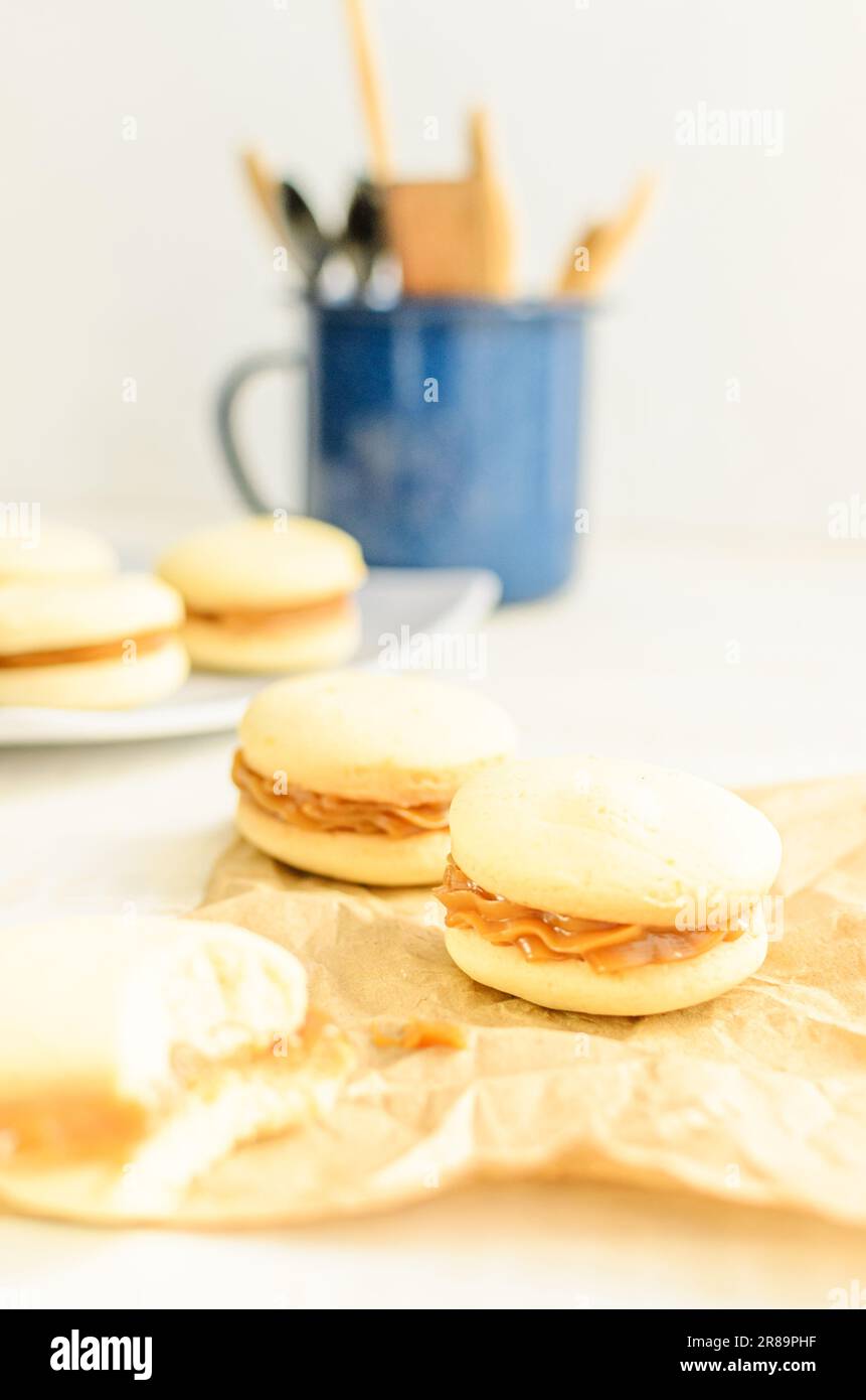 Alfajores cookies filled with dulce de leche. Stacked. Kitchen utensils ...