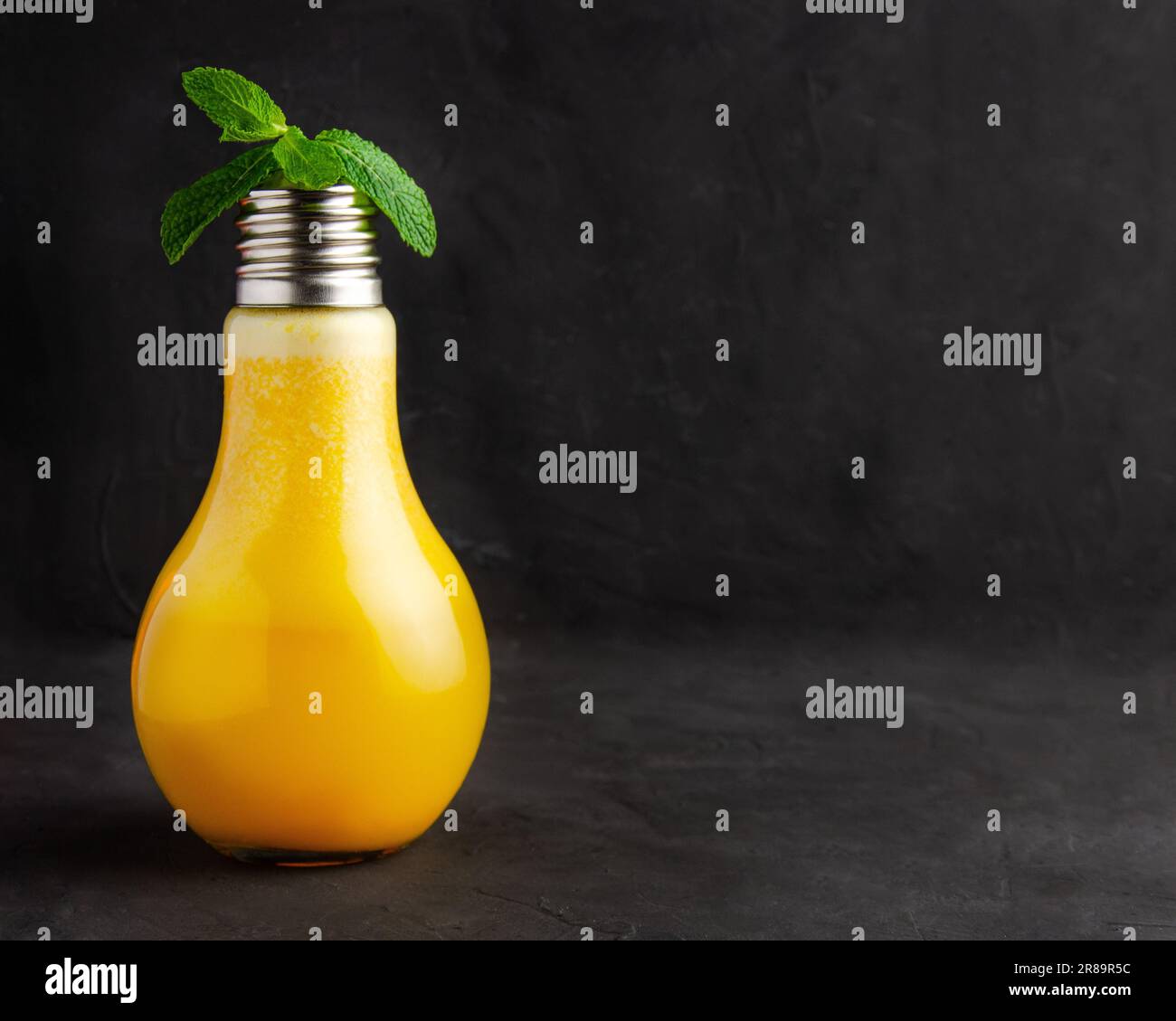 Passion Fruit juice and mint in a light bulb glass. Black background ...