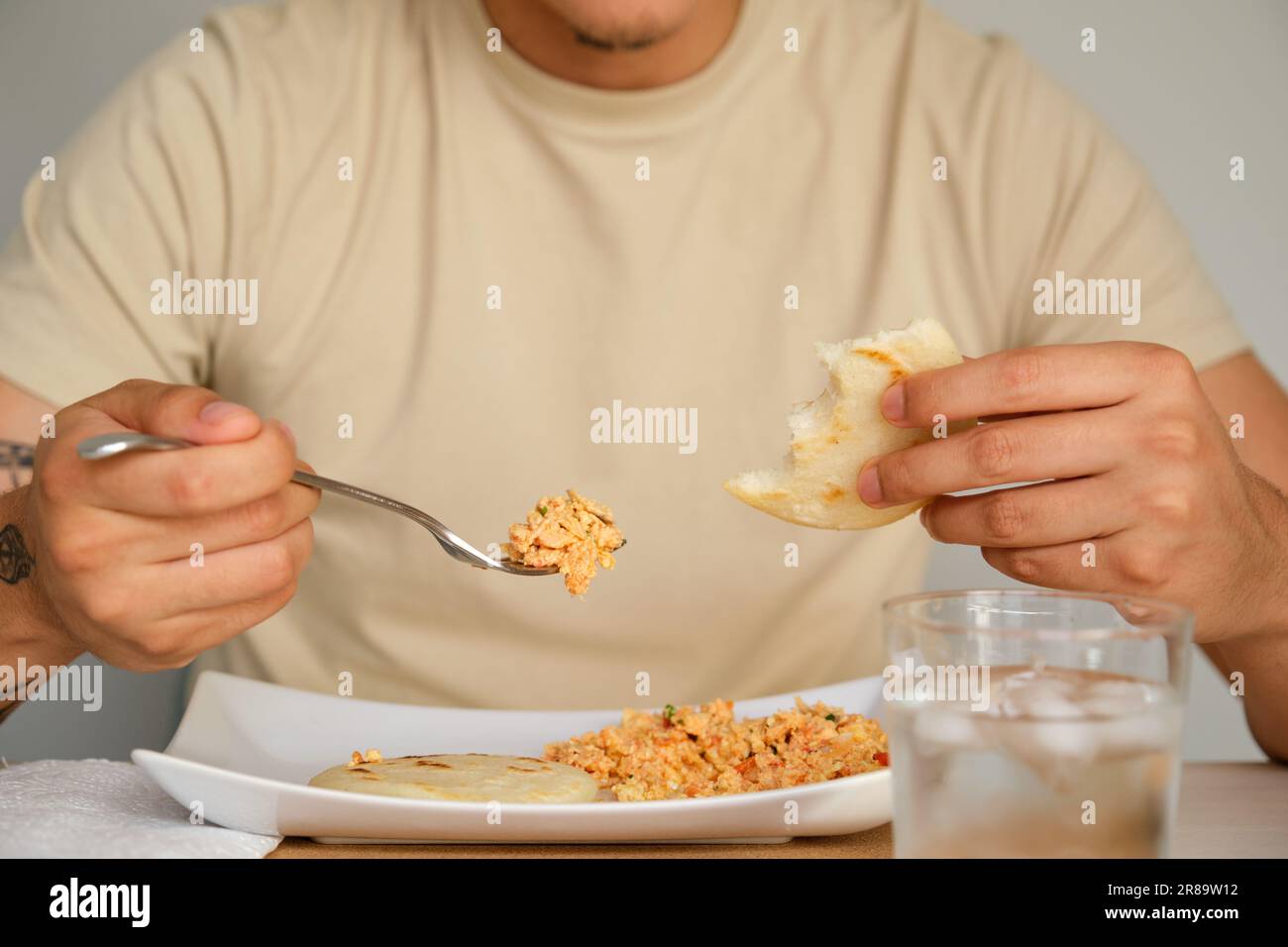 Close up of young hispanic man eating traditional arepas Stock Photo ...