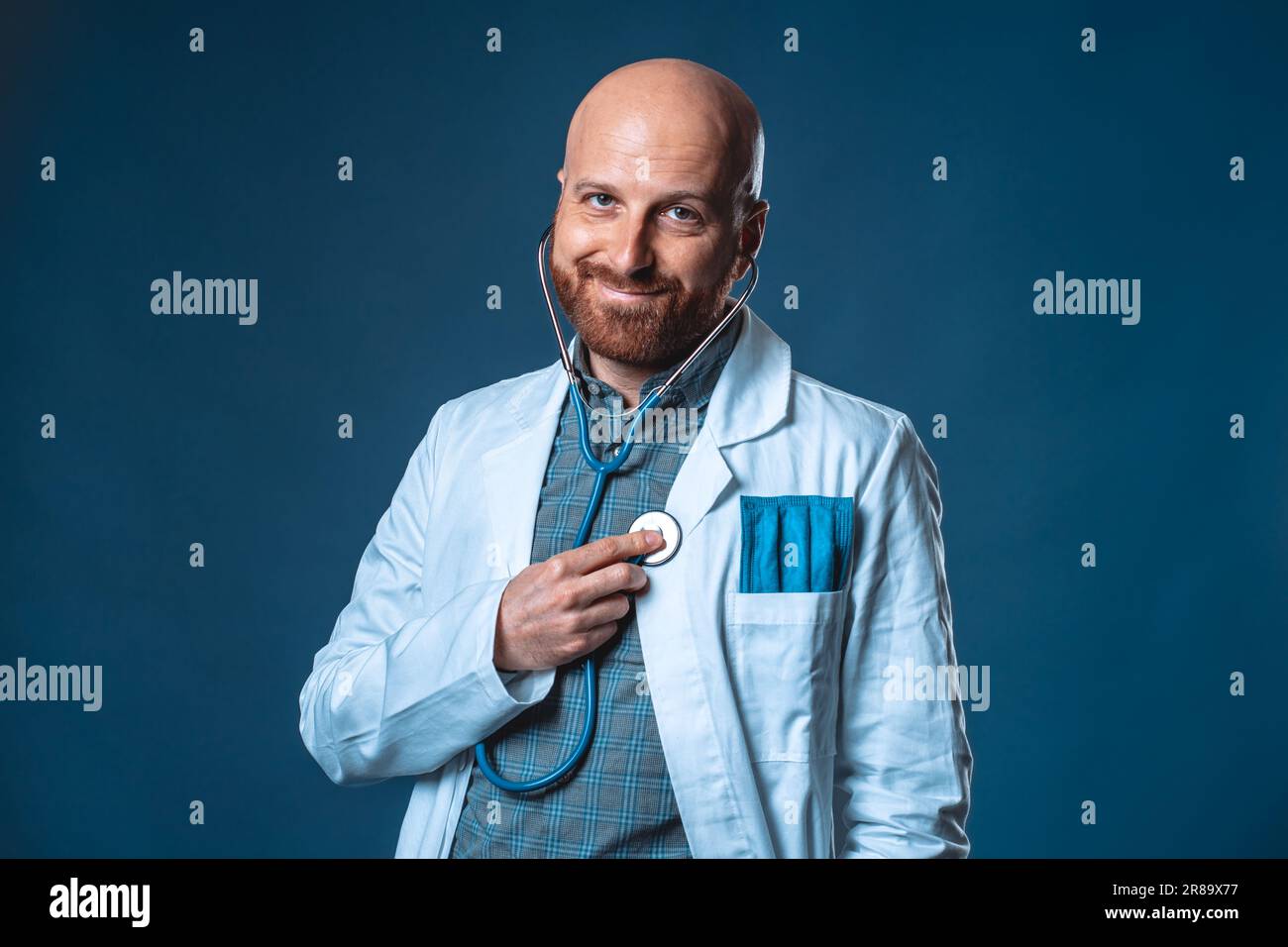 Photo of cheerful doctor with beard and stethoscope posing and smiling ...