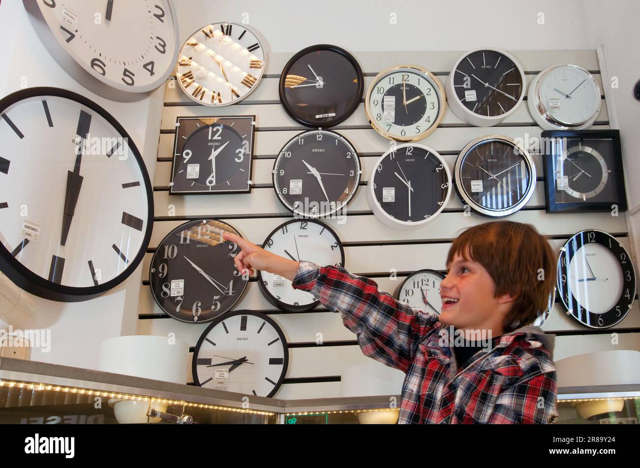 Netherlands, Velp. Boy in a shop full with analog clocks Stock Photo ...